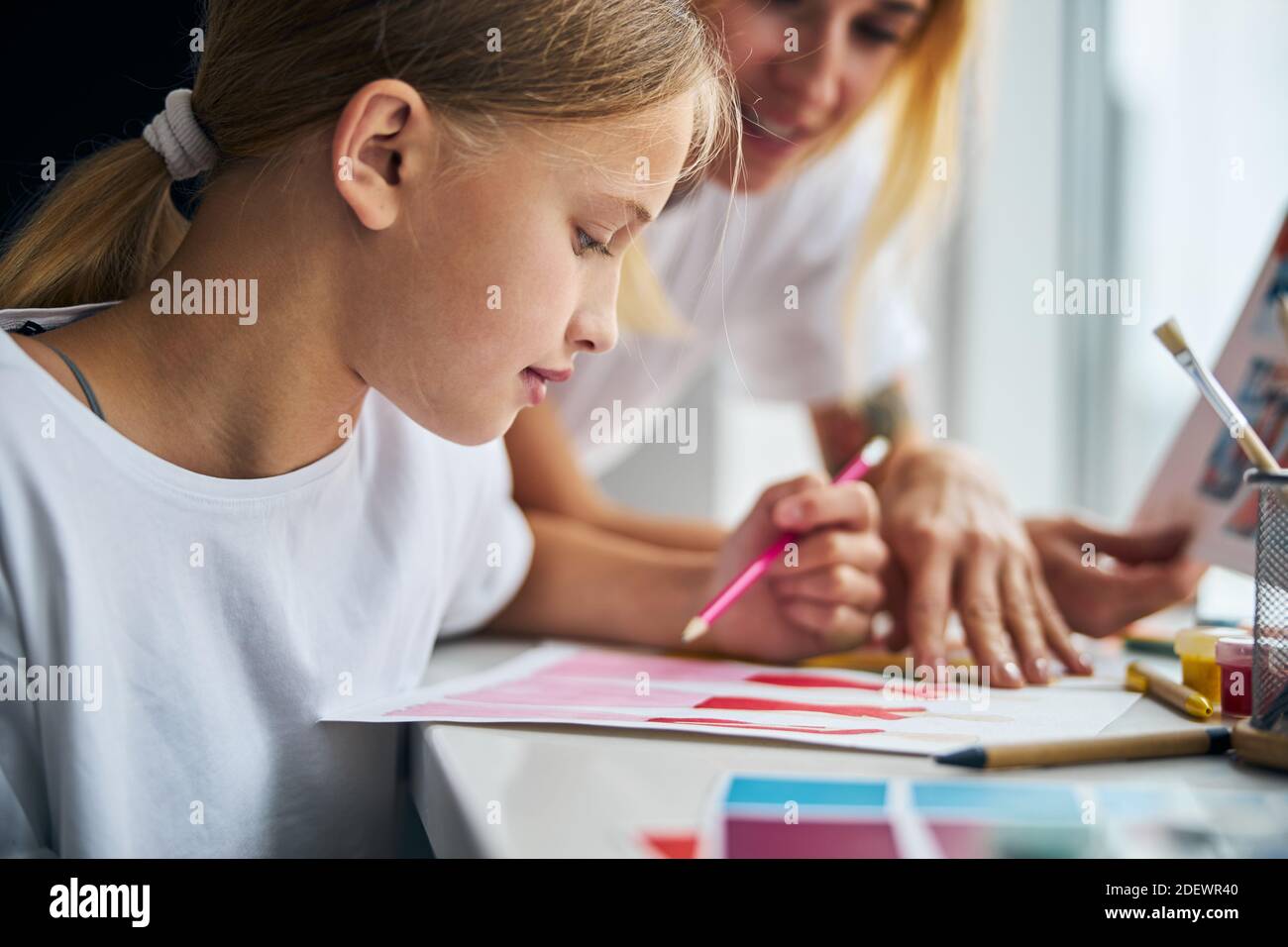 Two focused women looking at dress designs Stock Photo - Alamy