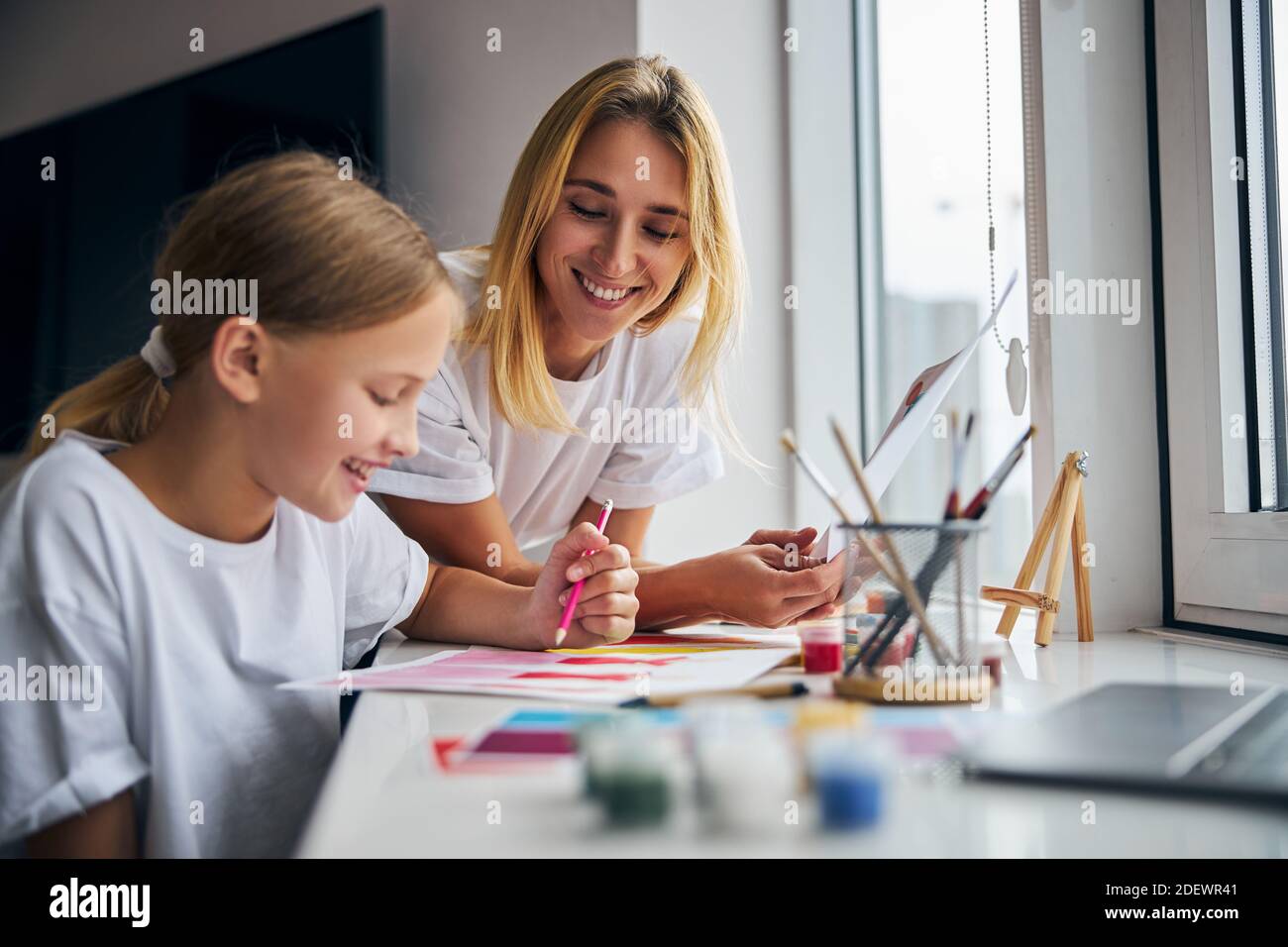 Pleased mother admiring drawings of her daughter Stock Photo - Alamy