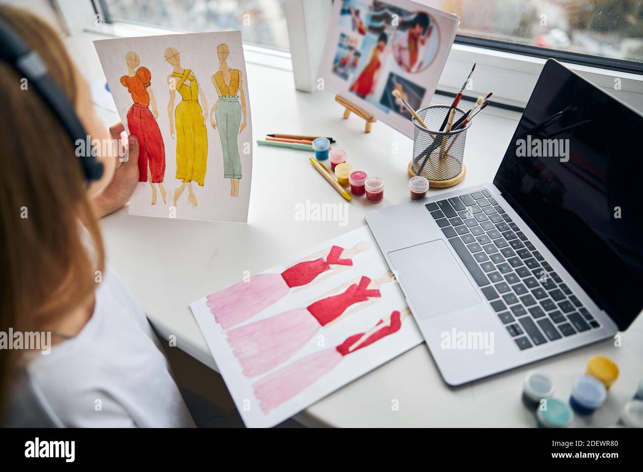 Girl in a t-shirt scrutinizing her drawings Stock Photo - Alamy