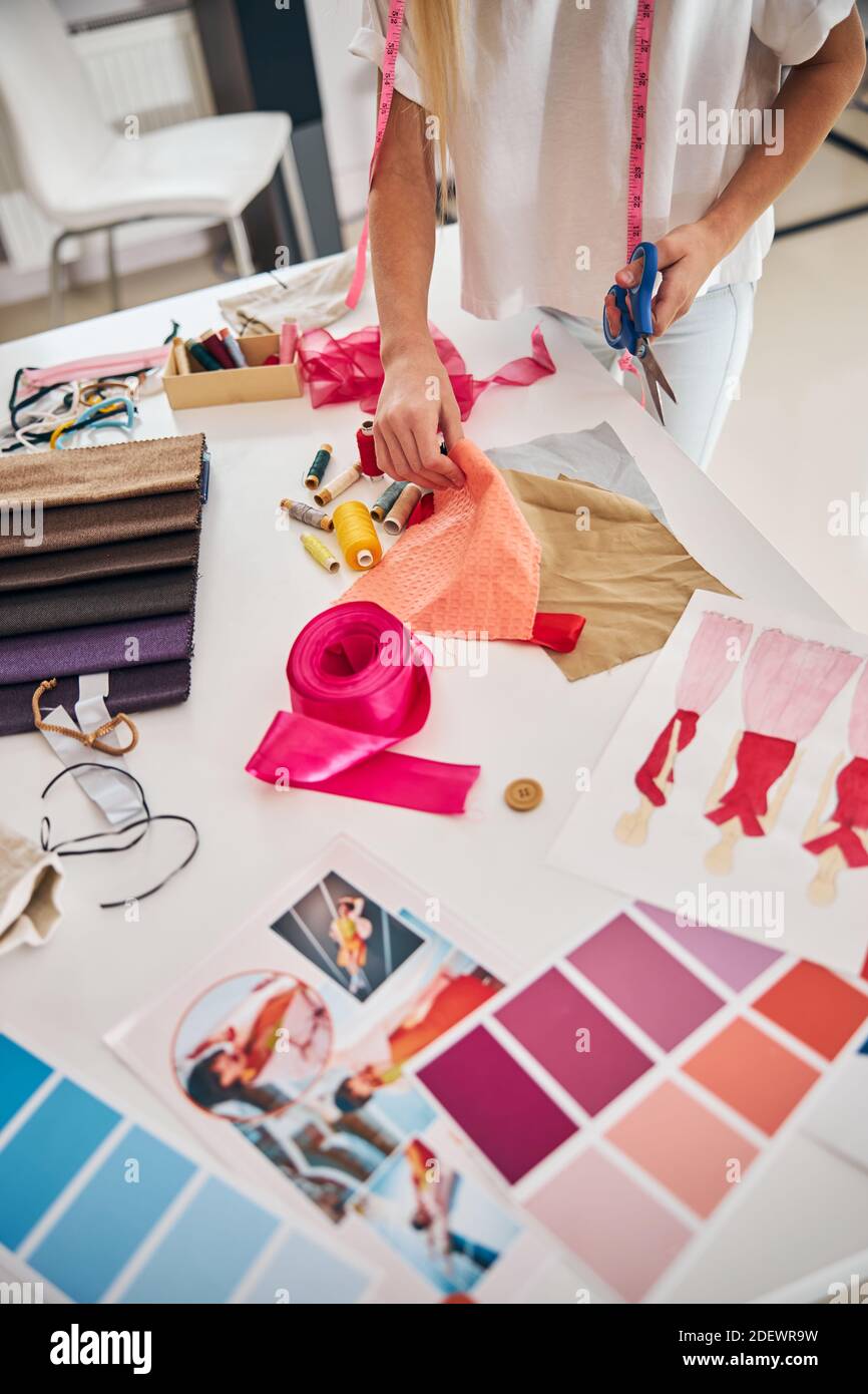 Dressmaker standing at the cutting table in her studio Stock Photo - Alamy