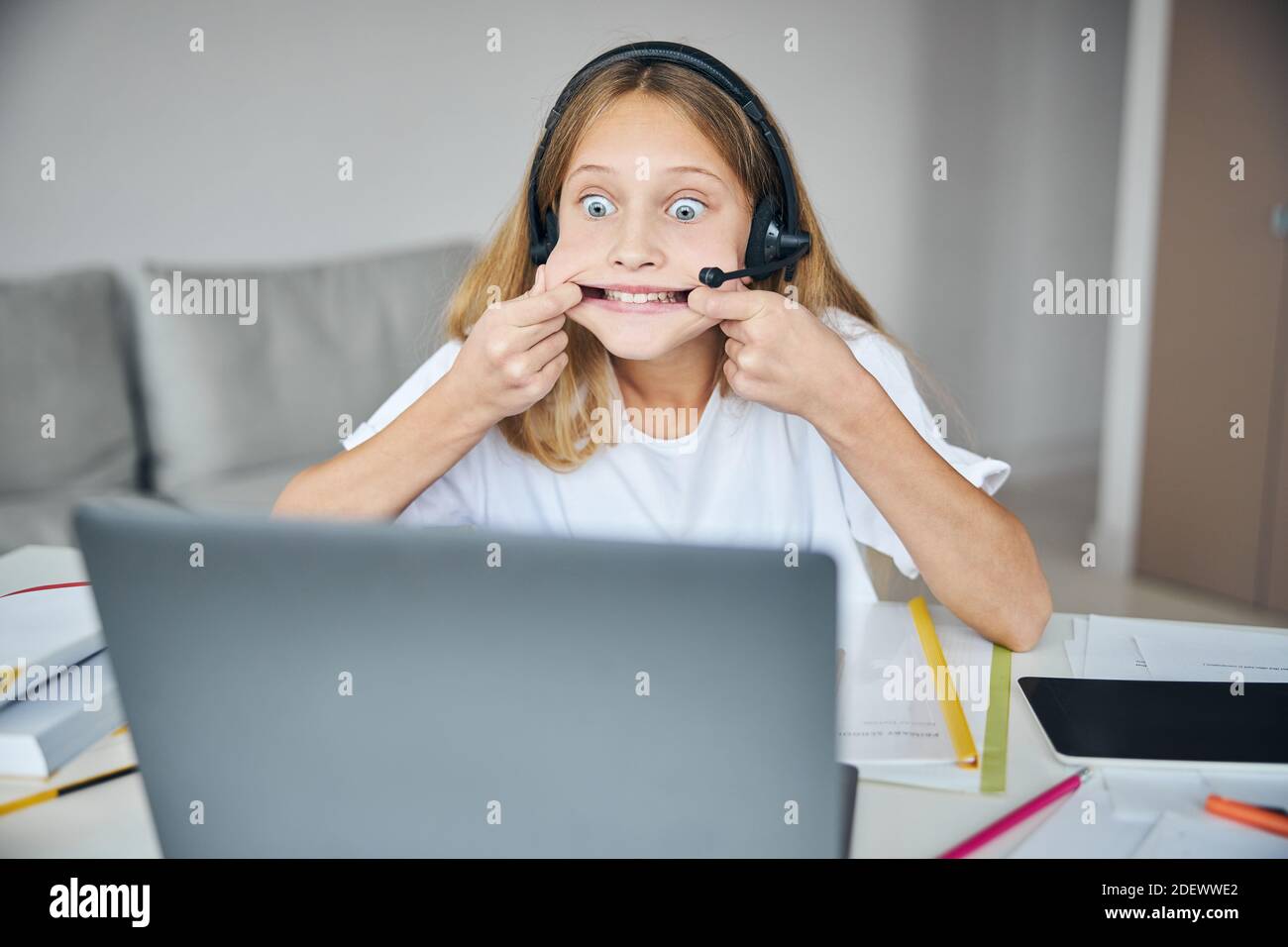 Young girl making a funny face to a laptop web-camera Stock Photo - Alamy