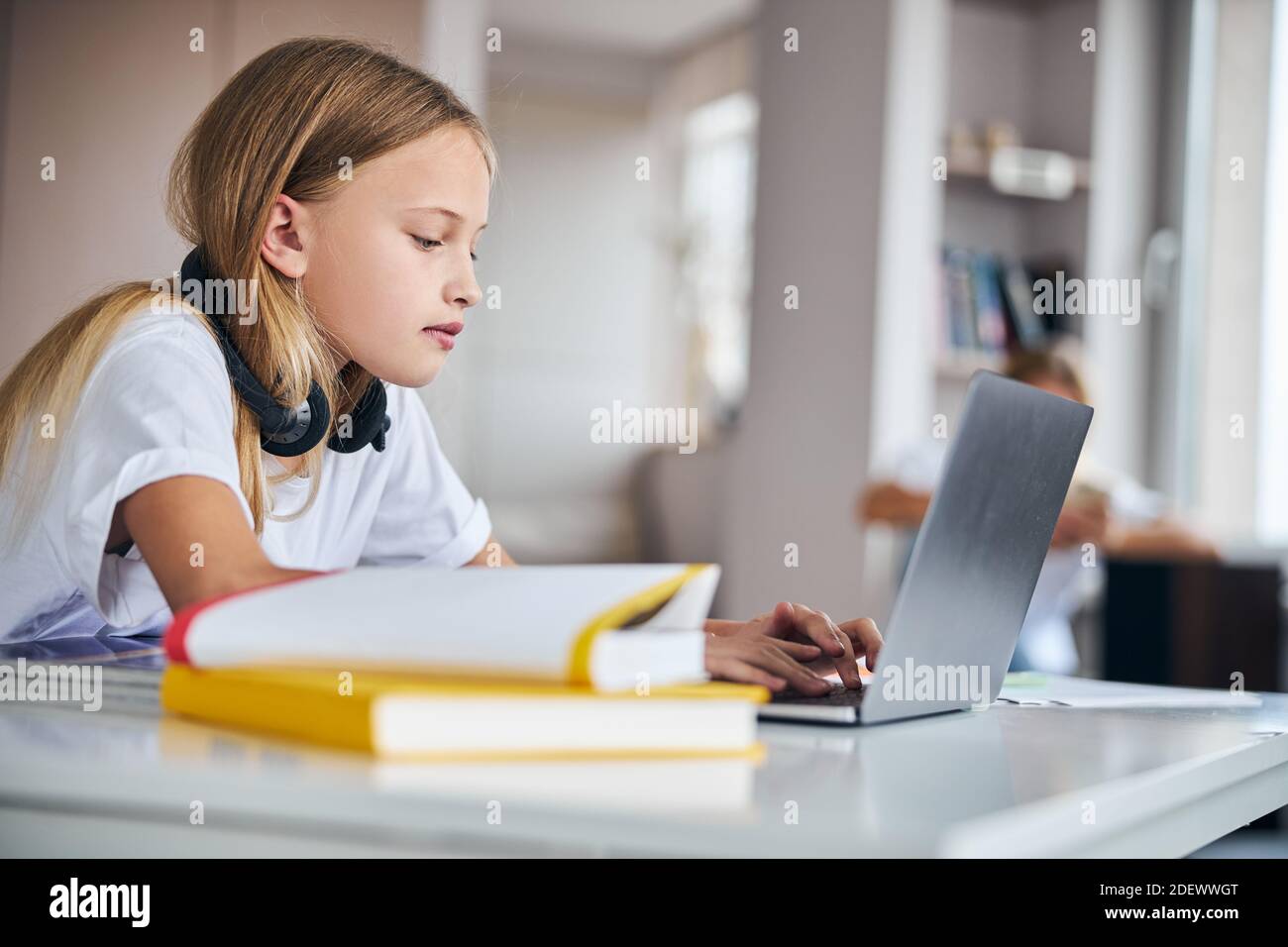 Teenage girl typing on a laptop keyboard Stock Photo - Alamy