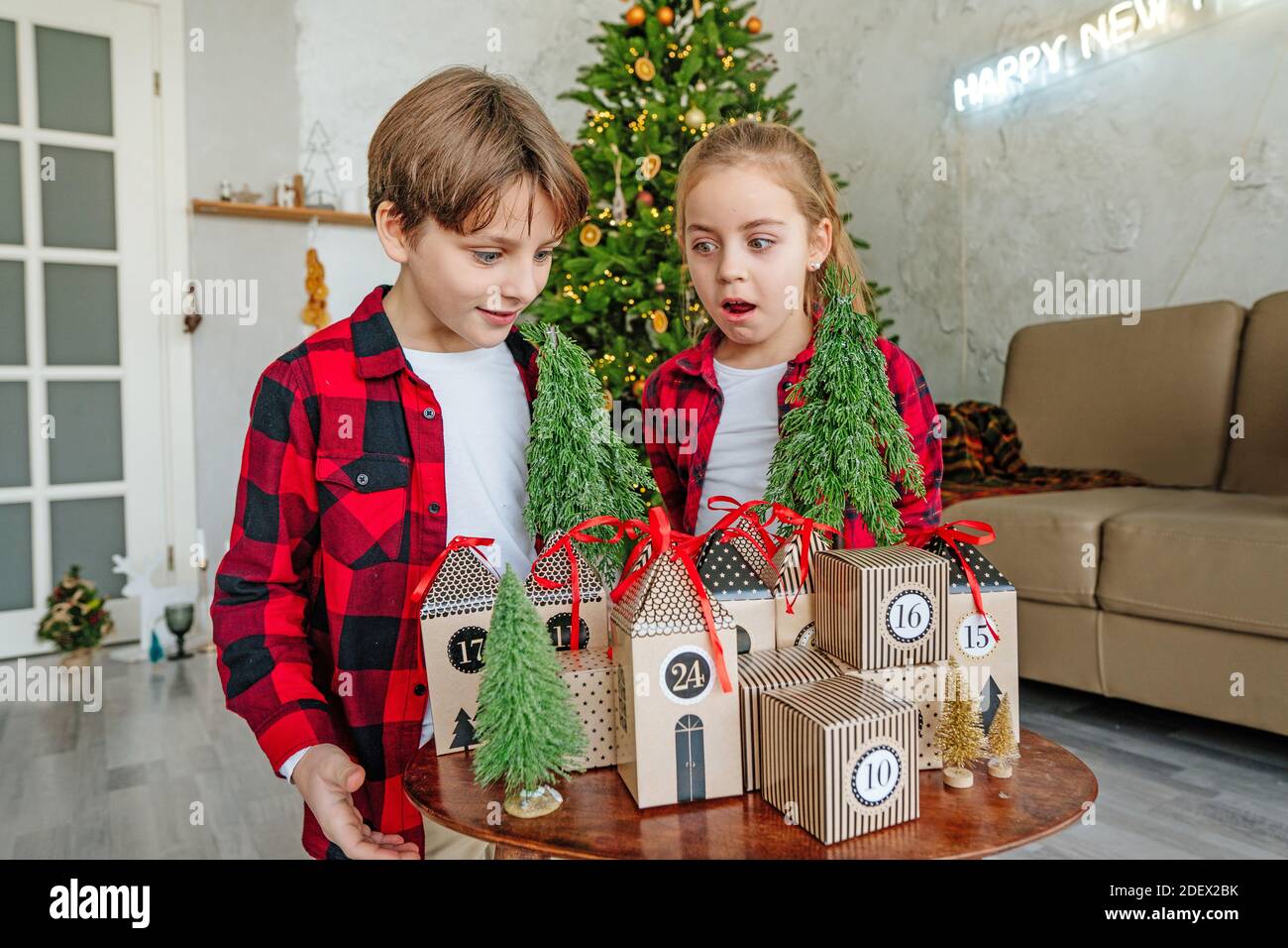 Children opening Christmas handmade advent calendar in a house shape to ...