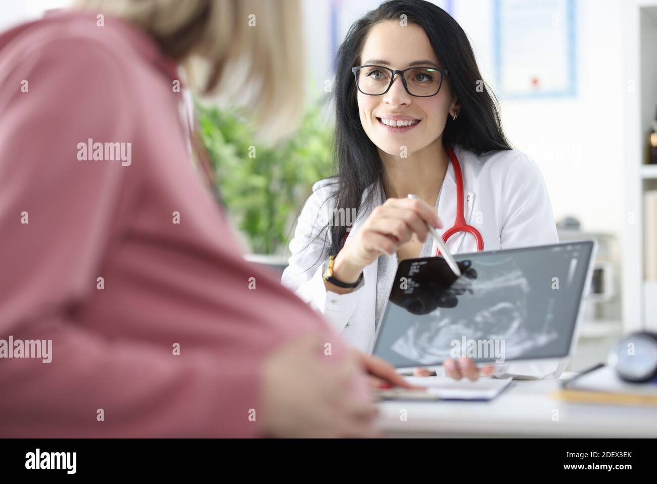 Female doctor demonstrates fetal ultrasound scan to pregnant woman ...