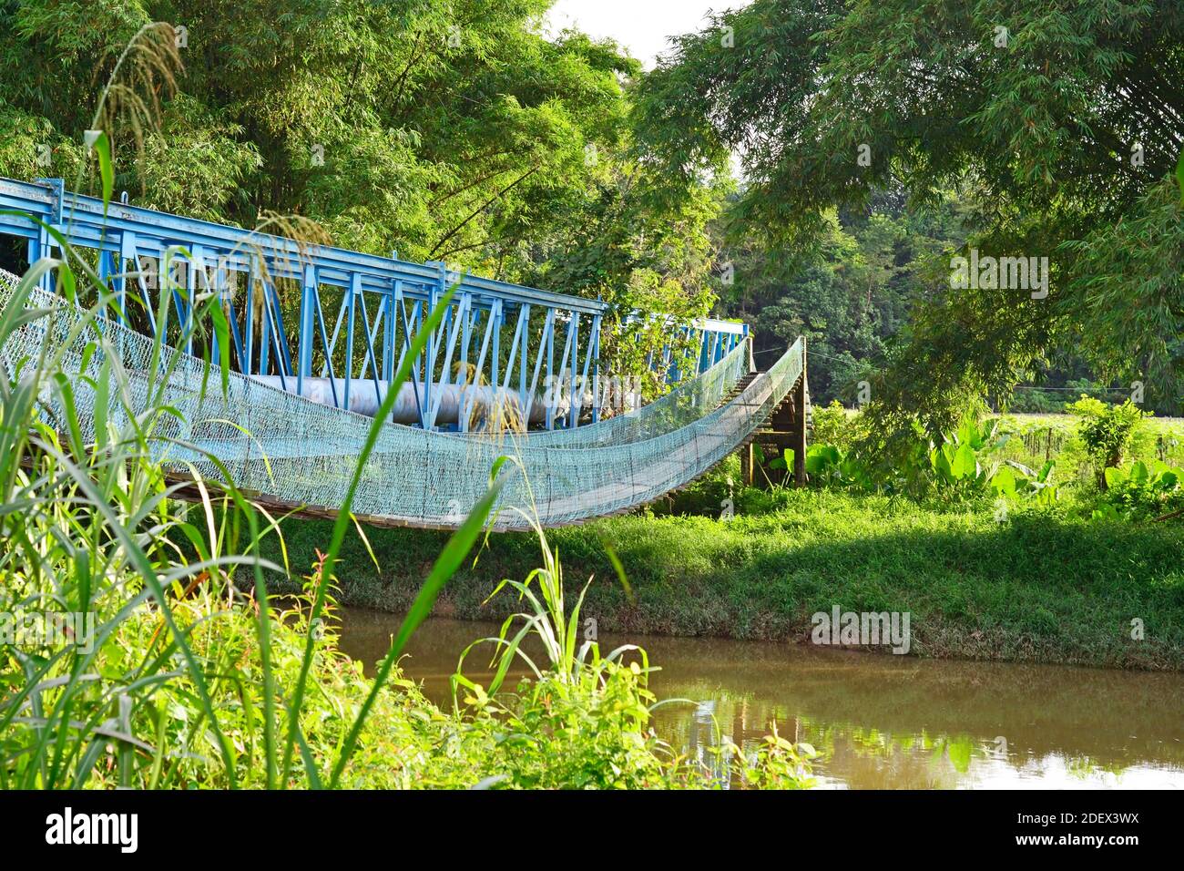 Water steel pipe and hanging bridge over river in rural area in ...