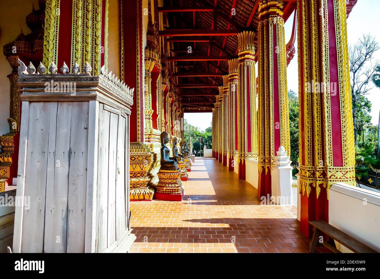 A historical old building aisle with ancient Buddha statues in ...