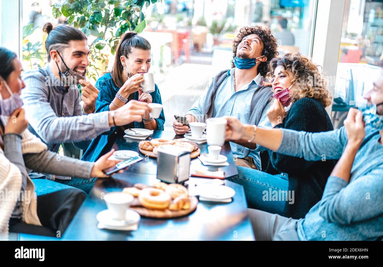 Friends having fun drinking and eating at coffeehouse - Young people talking together at ...