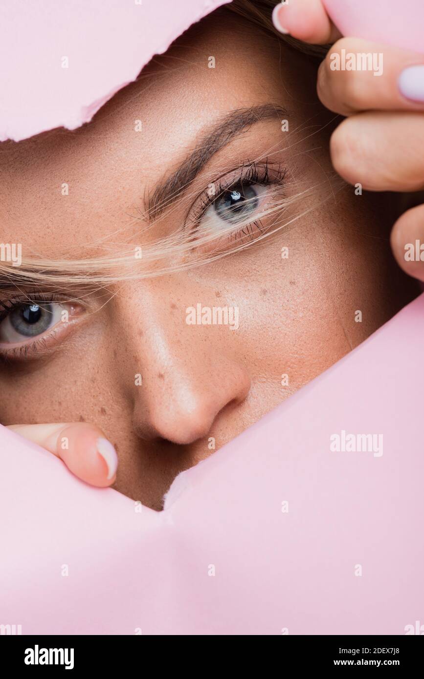 beautiful woman with freckles in pink paper hole Stock Photo - Alamy