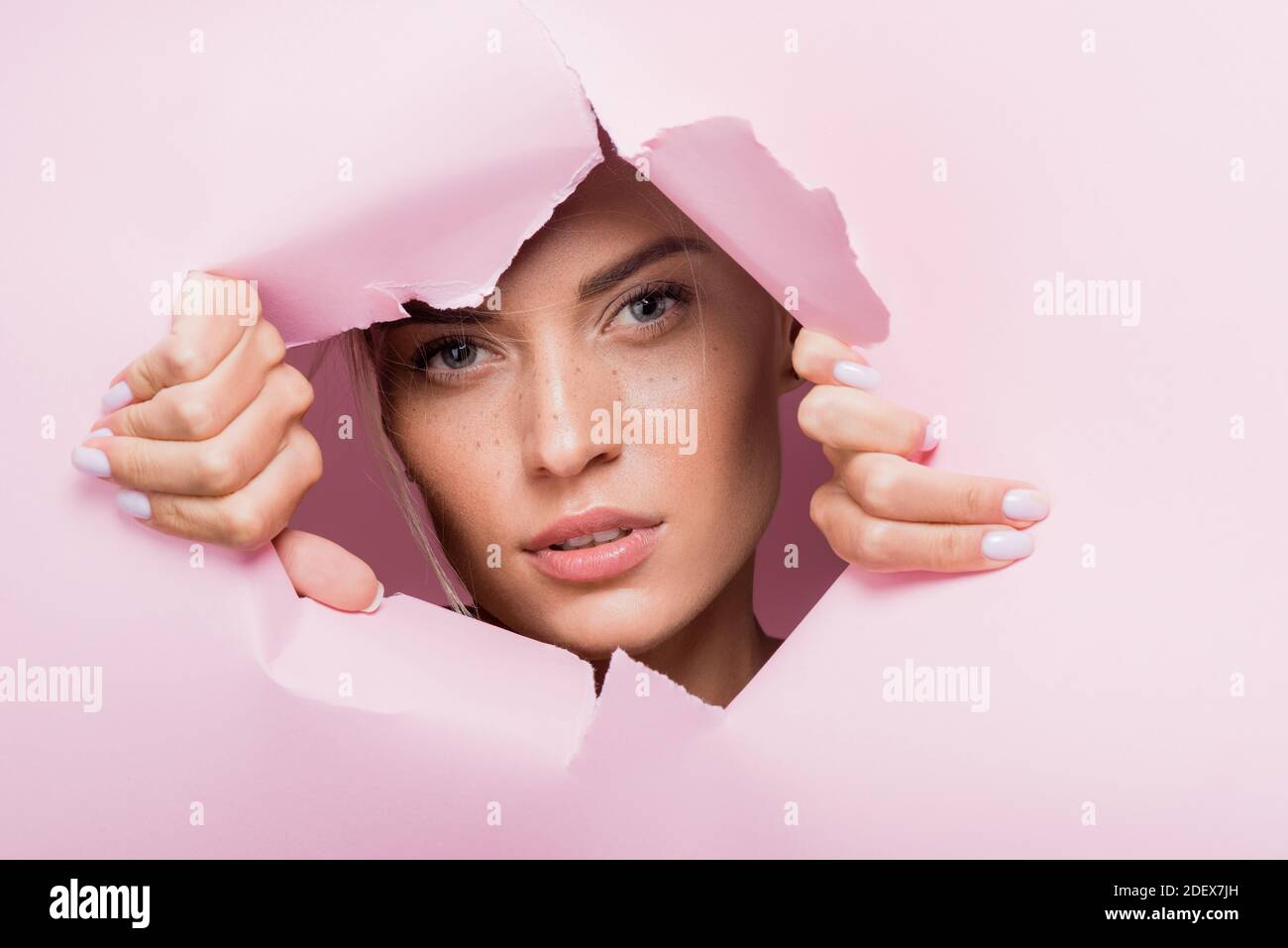 beautiful woman with freckles in pink paper hole Stock Photo - Alamy