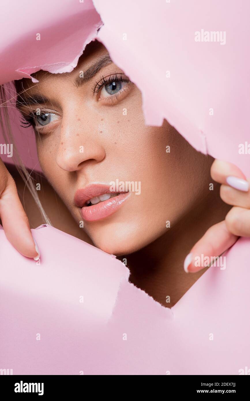beautiful woman with freckles in pink paper hole Stock Photo - Alamy