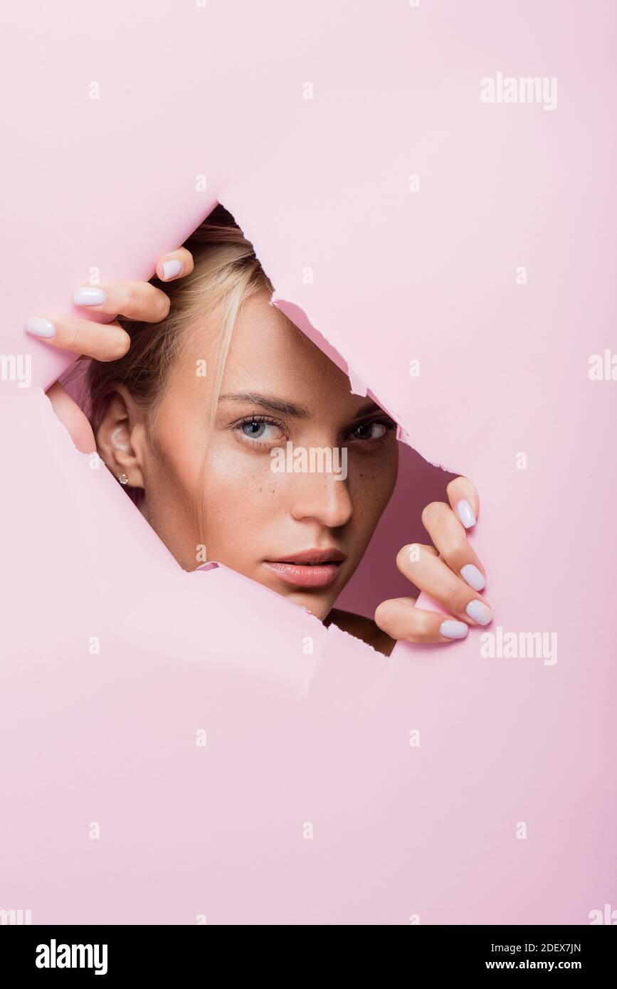 beautiful woman with freckles in pink paper hole Stock Photo - Alamy