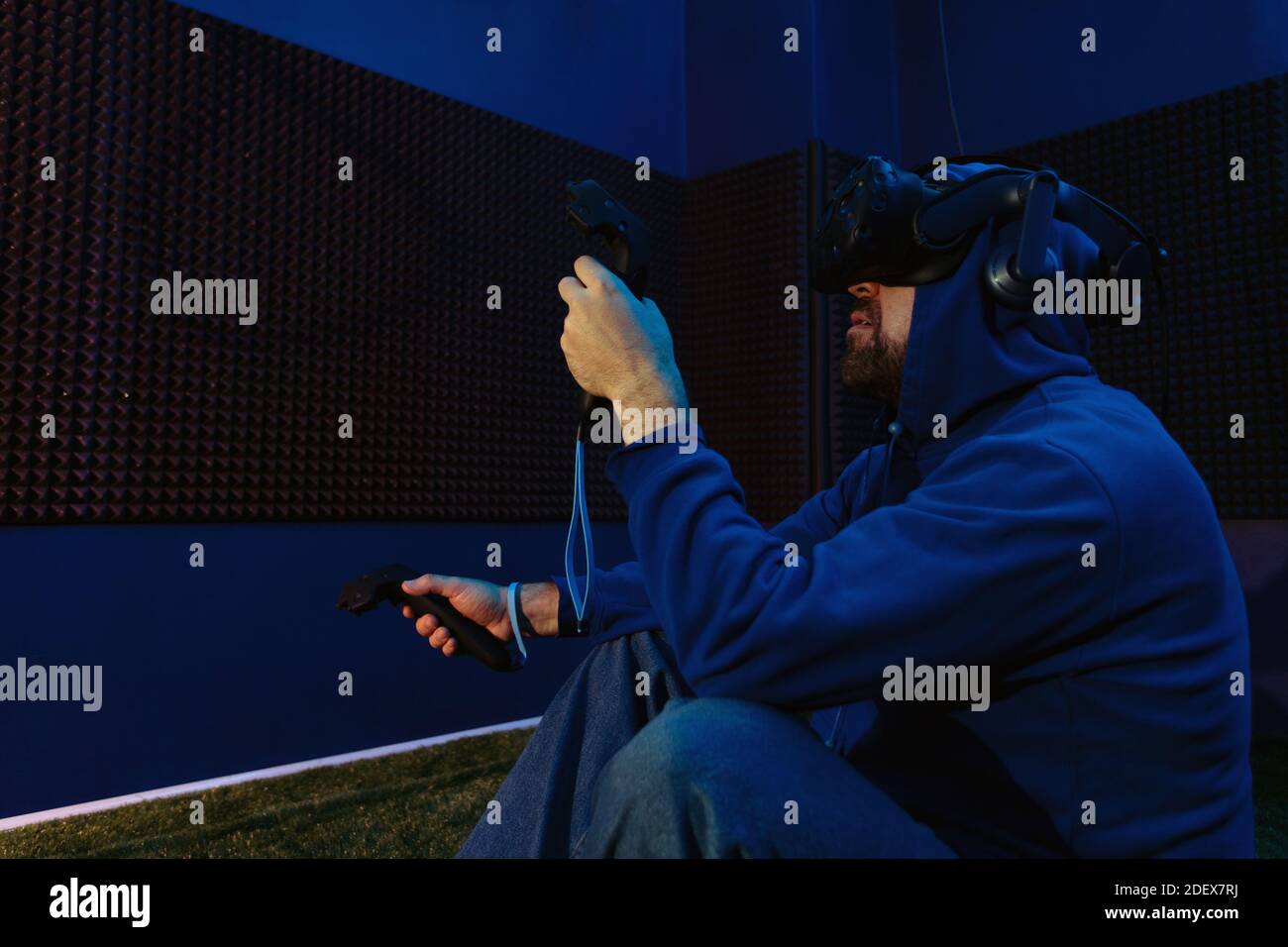 Contemporary man in virtual reality headset using joystick while ...