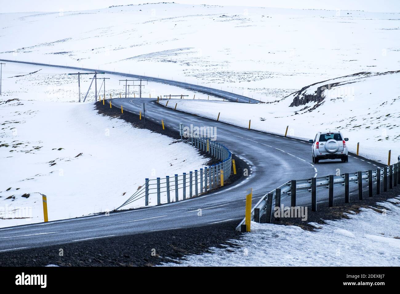 car driving along a winding road through snow covered tundra Stock ...