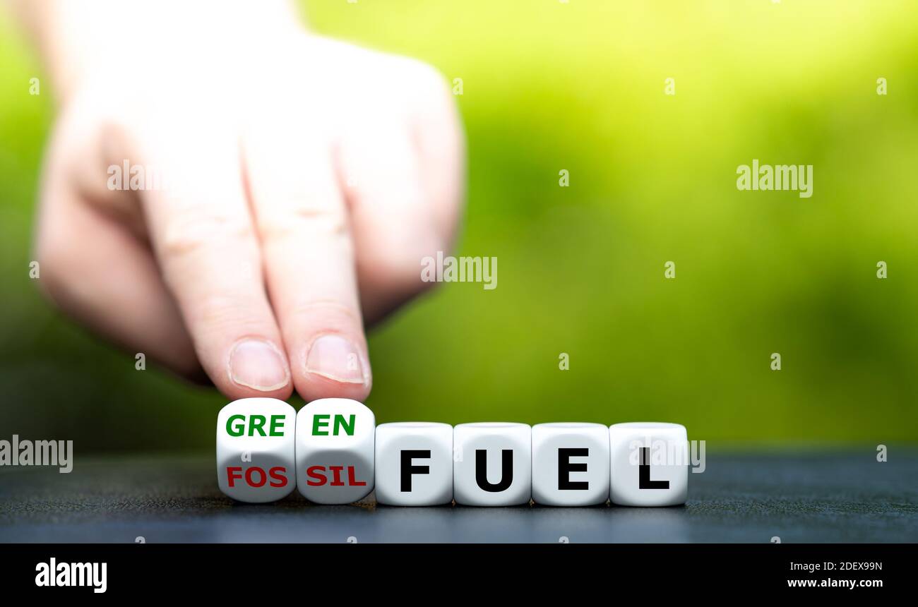Hand turns dice and changes the expression "fossil fuel" to "green fuel ...