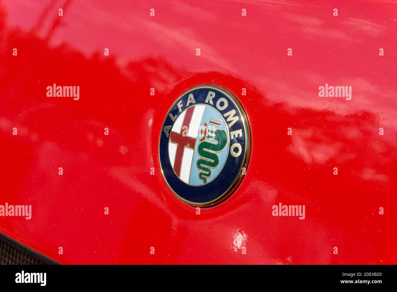Close up of the brand logo emblem badge on the front of a red Alfa ...