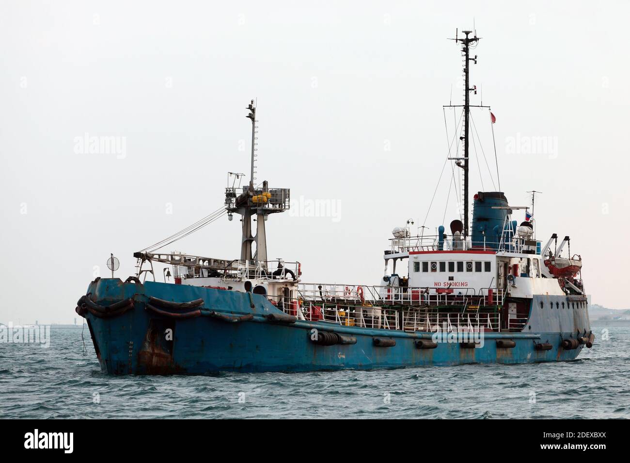 Old rusty ship coming into a port Stock Photo - Alamy