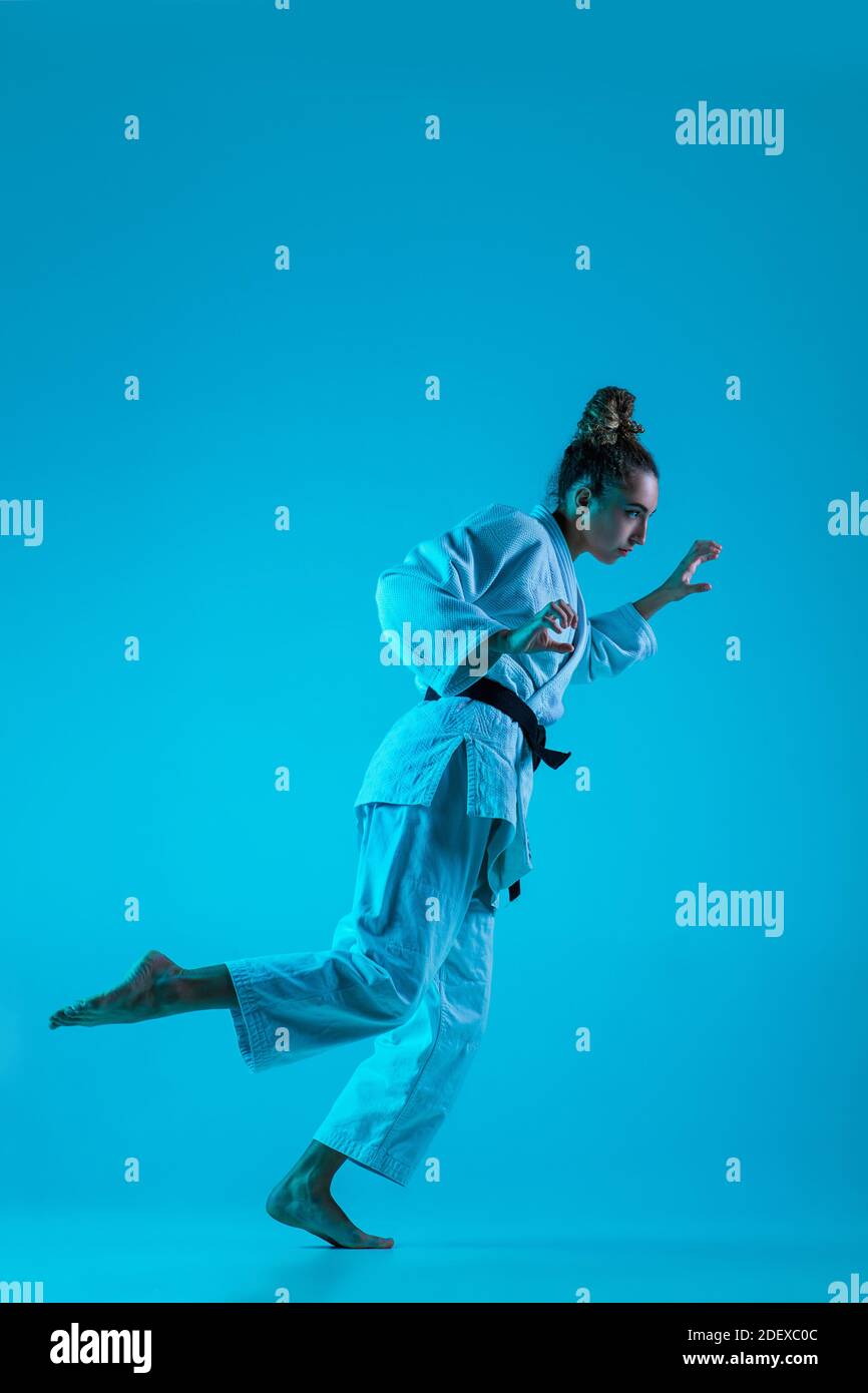 Active training. Professional female judoist in white judo kimono ...