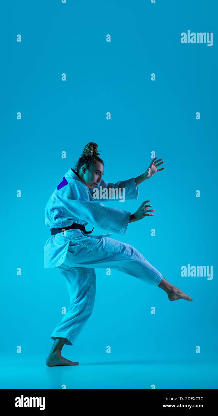 Active training. Professional female judoist in white judo kimono ...