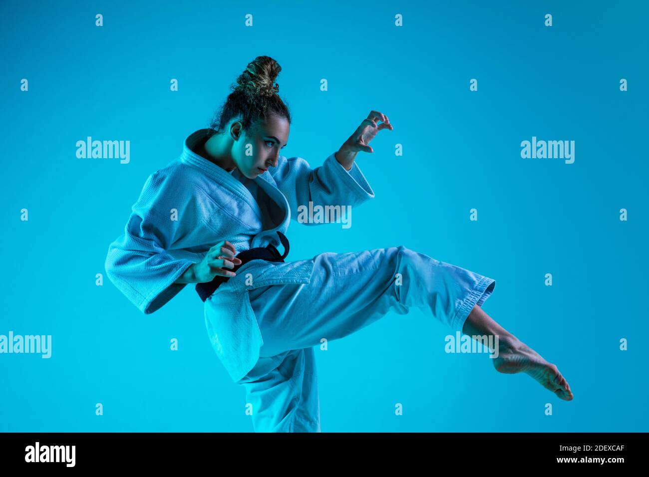 Active training. Professional female judoist in white judo kimono ...