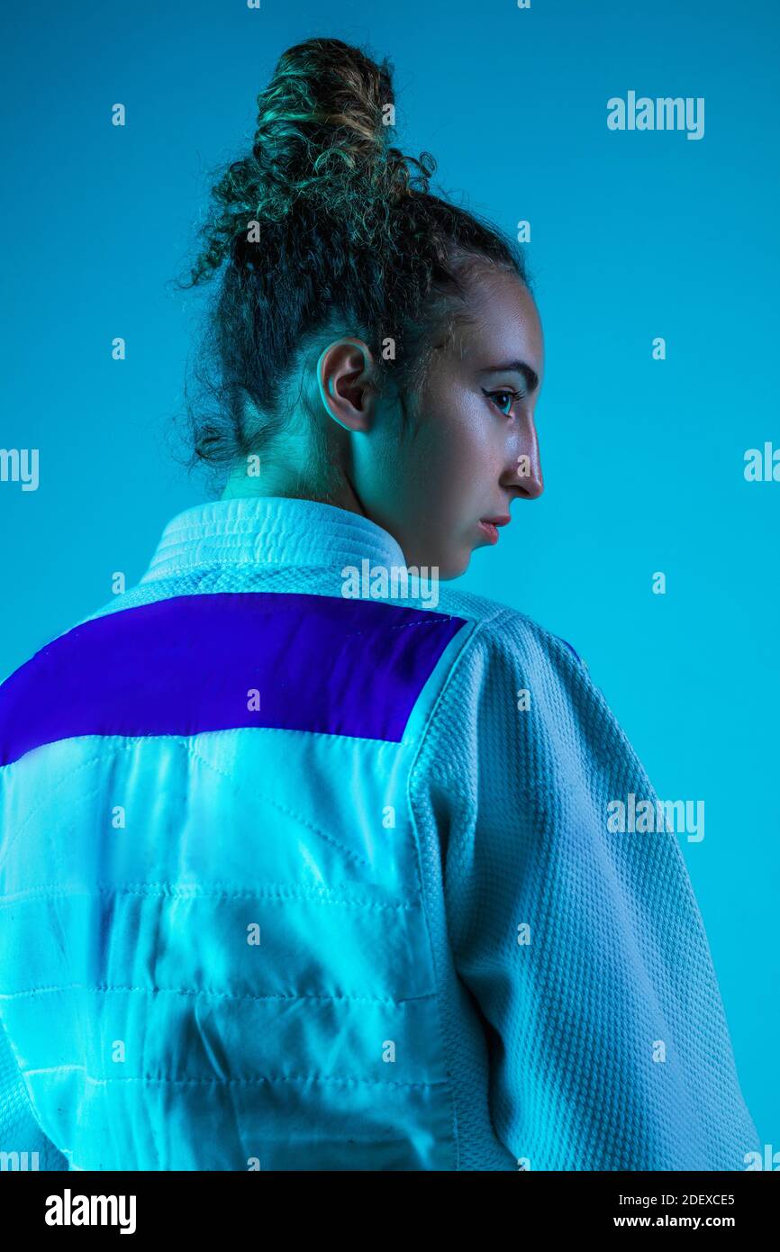 Posing. Professional female judoist in white judo kimono practicing and ...