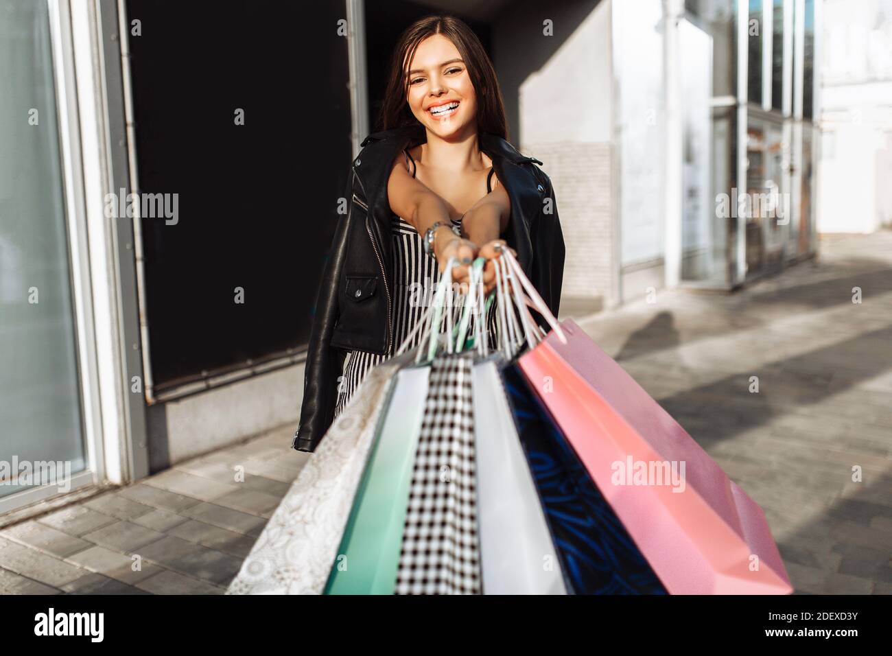 Young girl enjoying a successful shopping, walking down the street ...