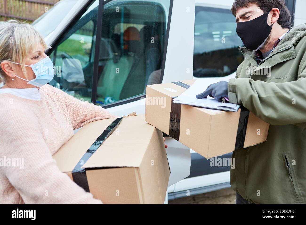 Parcel carrier with a face mask when delivering parcels at Christmas ...