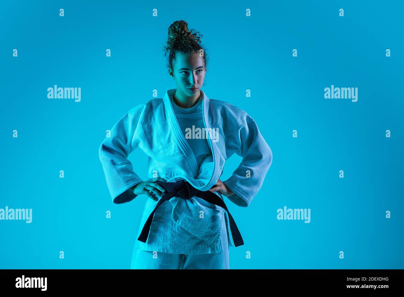 Posing. Professional female judoist in white judo kimono practicing and ...