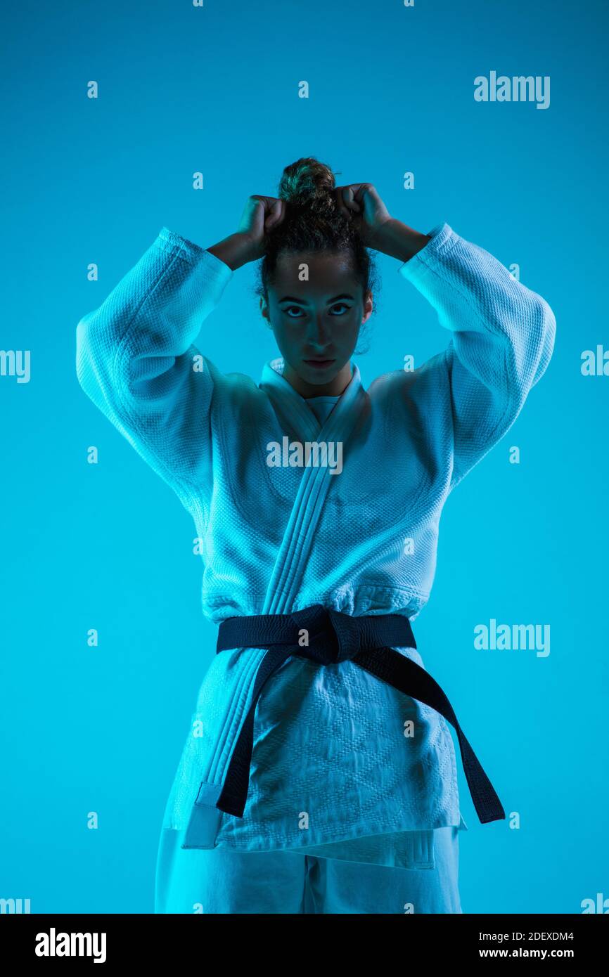 Posing. Professional female judoist in white judo kimono practicing and ...