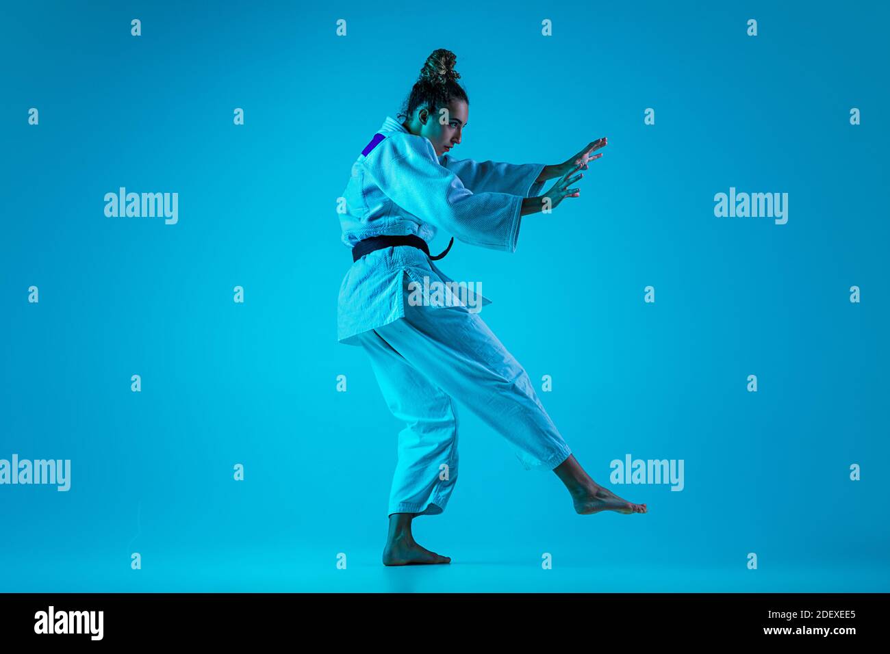 Active training. Professional female judoist in white judo kimono ...