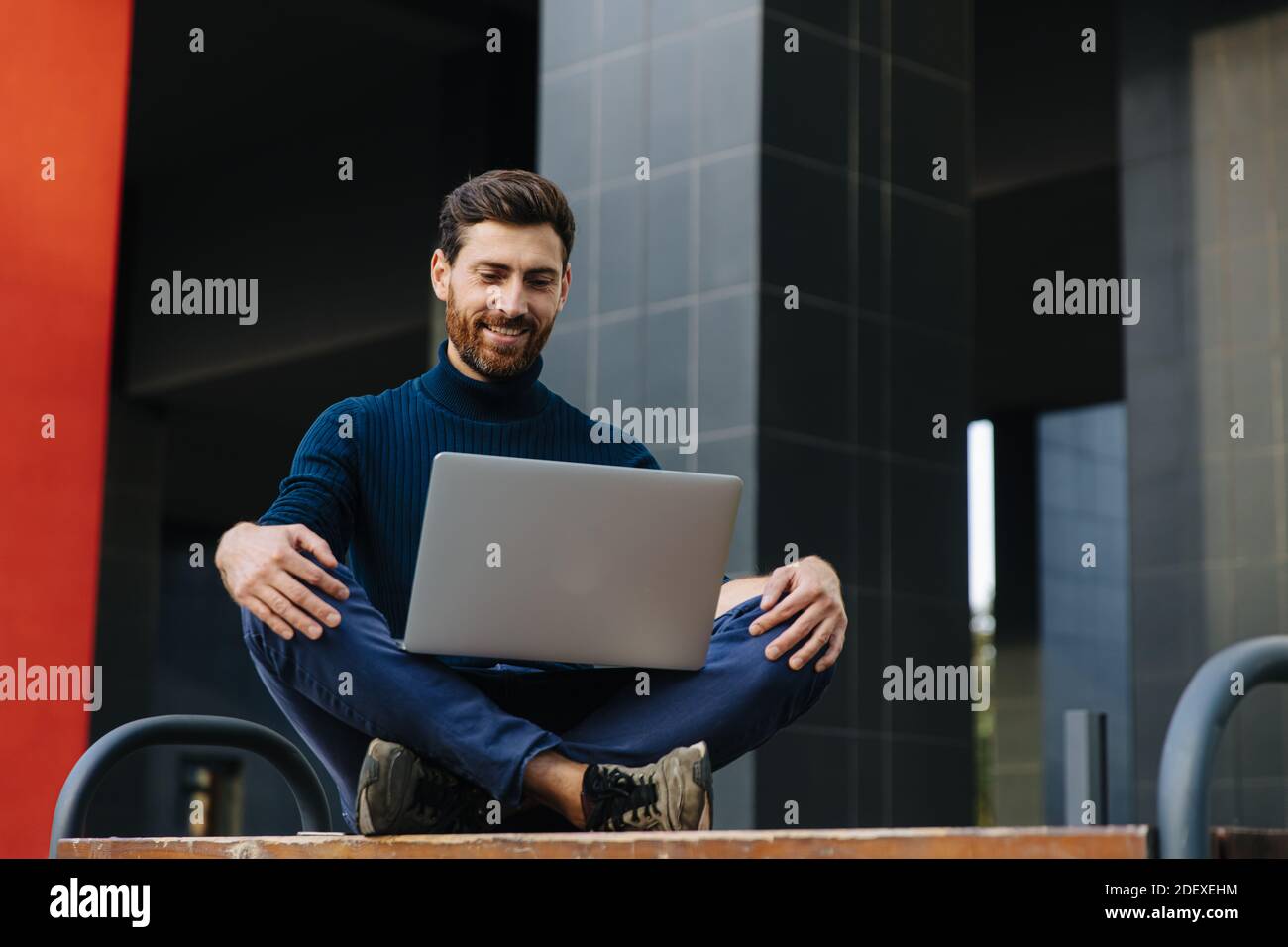 Stylish man looking at computer screen outdoors Stock Photo - Alamy