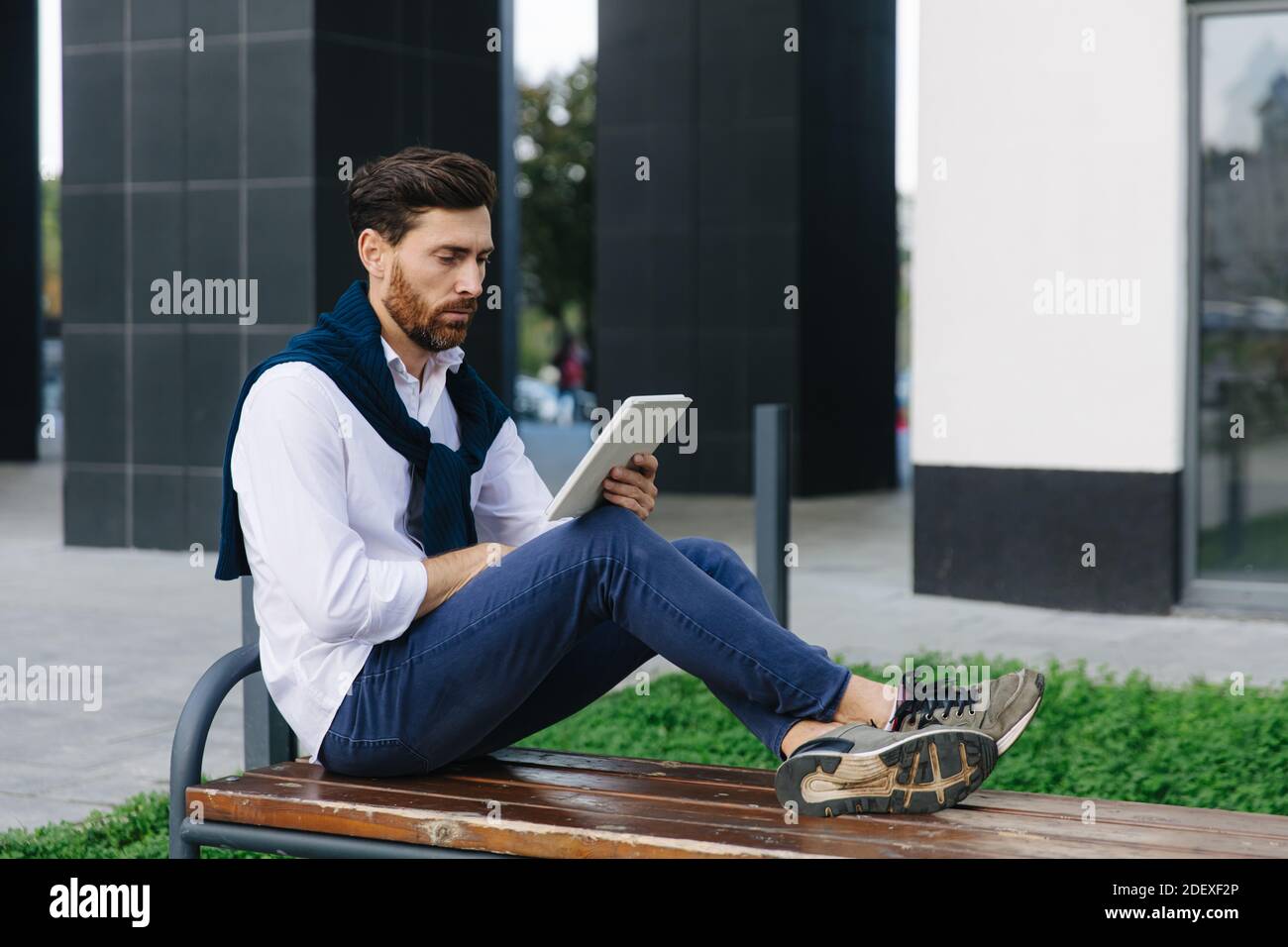 Stylish man using tablet during leisure time outdoors Stock Photo - Alamy