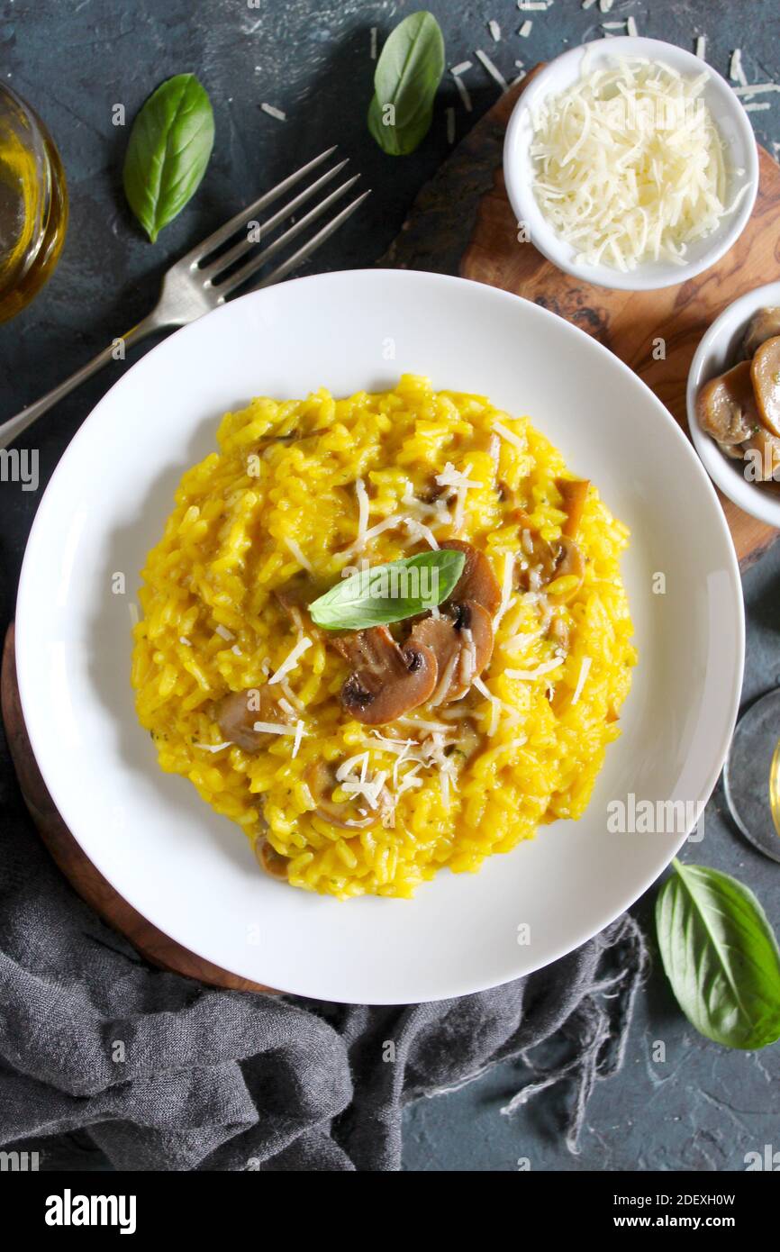 Italian risotto with mushrooms, saffron and parmesan cheese on dark ...