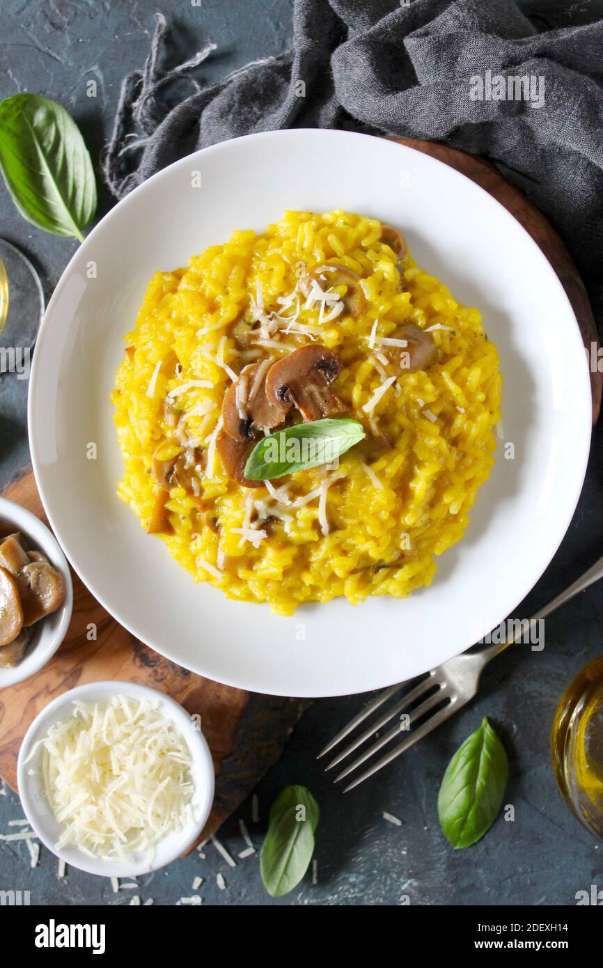 Italian risotto with mushrooms, saffron and parmesan cheese on dark ...