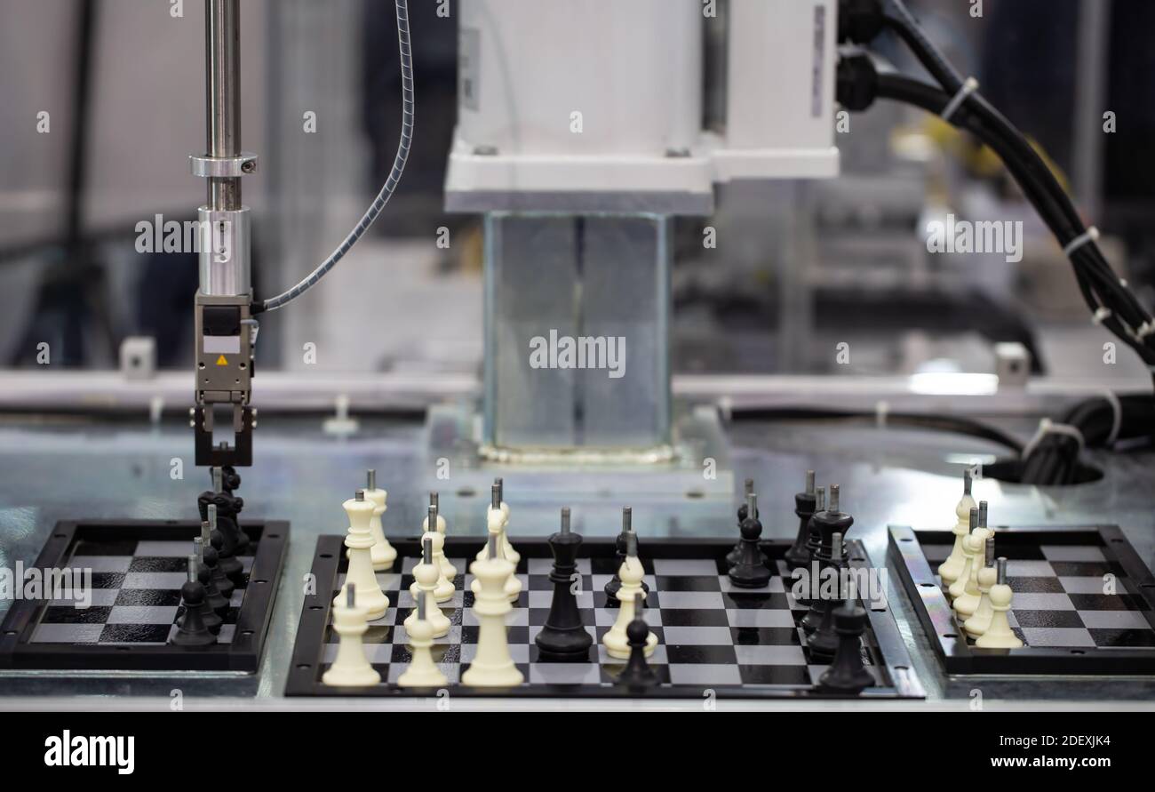 Industrial robot playing chess. Artificial Intelligence AI technology ...