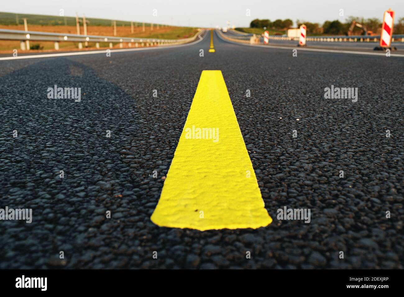 Yellow road markings on asphalt road close up Stock Photo - Alamy