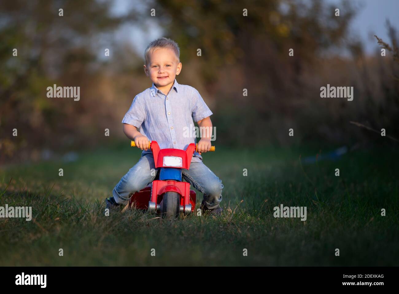Little boy rides a red bike in summer Stock Photo - Alamy