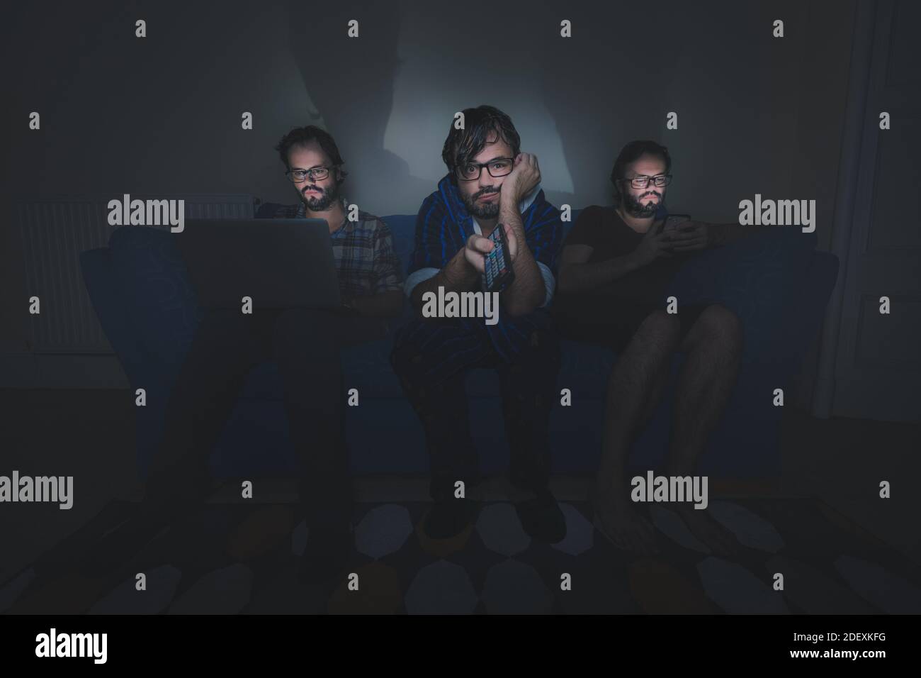Multiple exposures of a man bored at home and hooked onto his devices ...