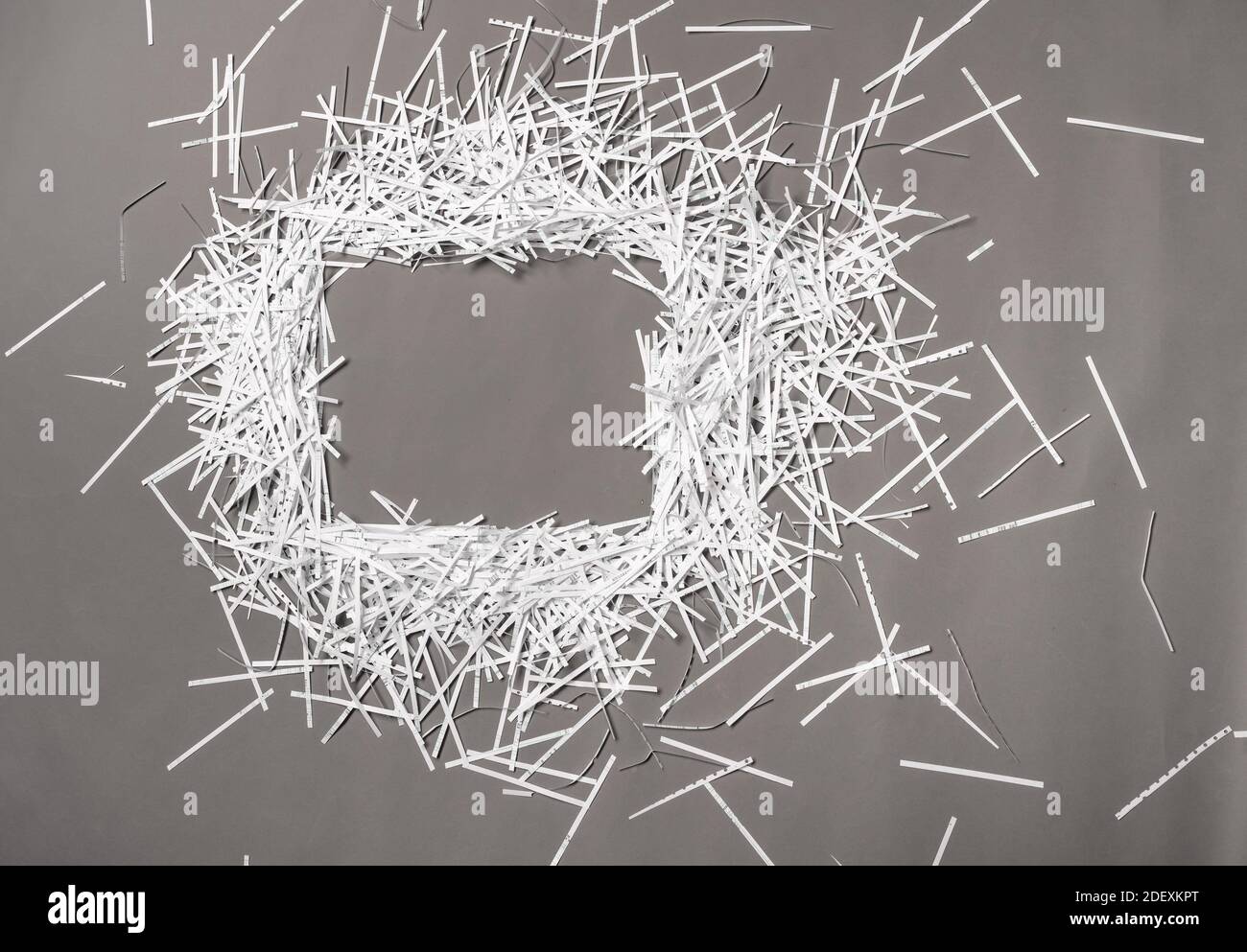 White paper cut stripes form a square on a grey background. seen from ...