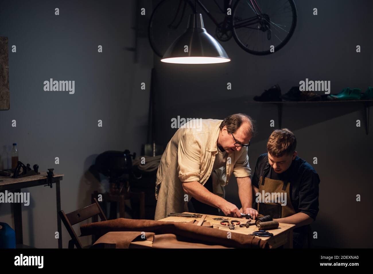 father-shoemaker prepares a successor in the family business of manual ...