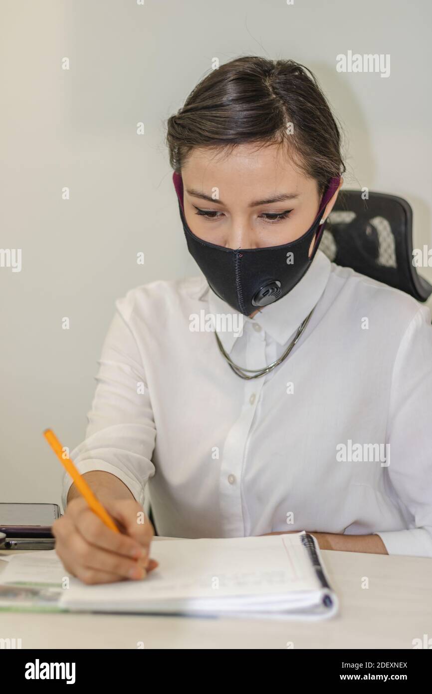 Business woman working in office wearing face mask due to covid19 ...