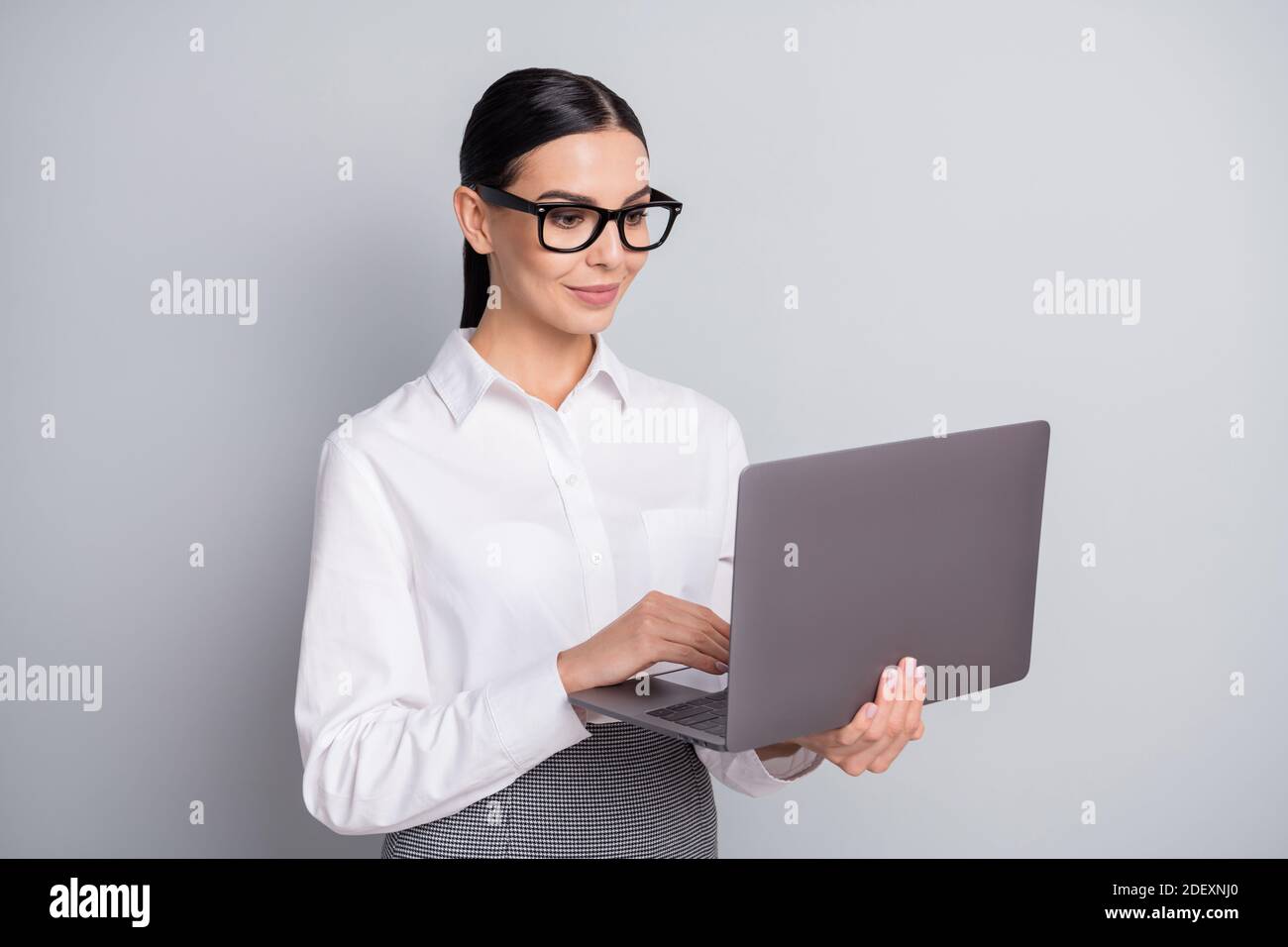 Photo of calm programmer girl hold laptop look screen wear eyeglasses ...