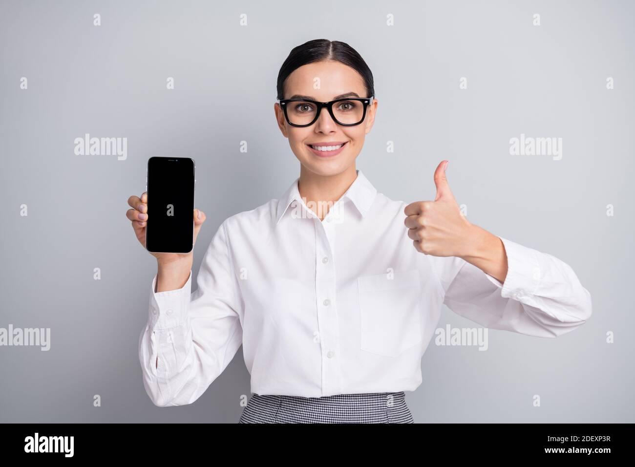 Photo of pretty promoter girl hold phone screen empty space raise thumb ...