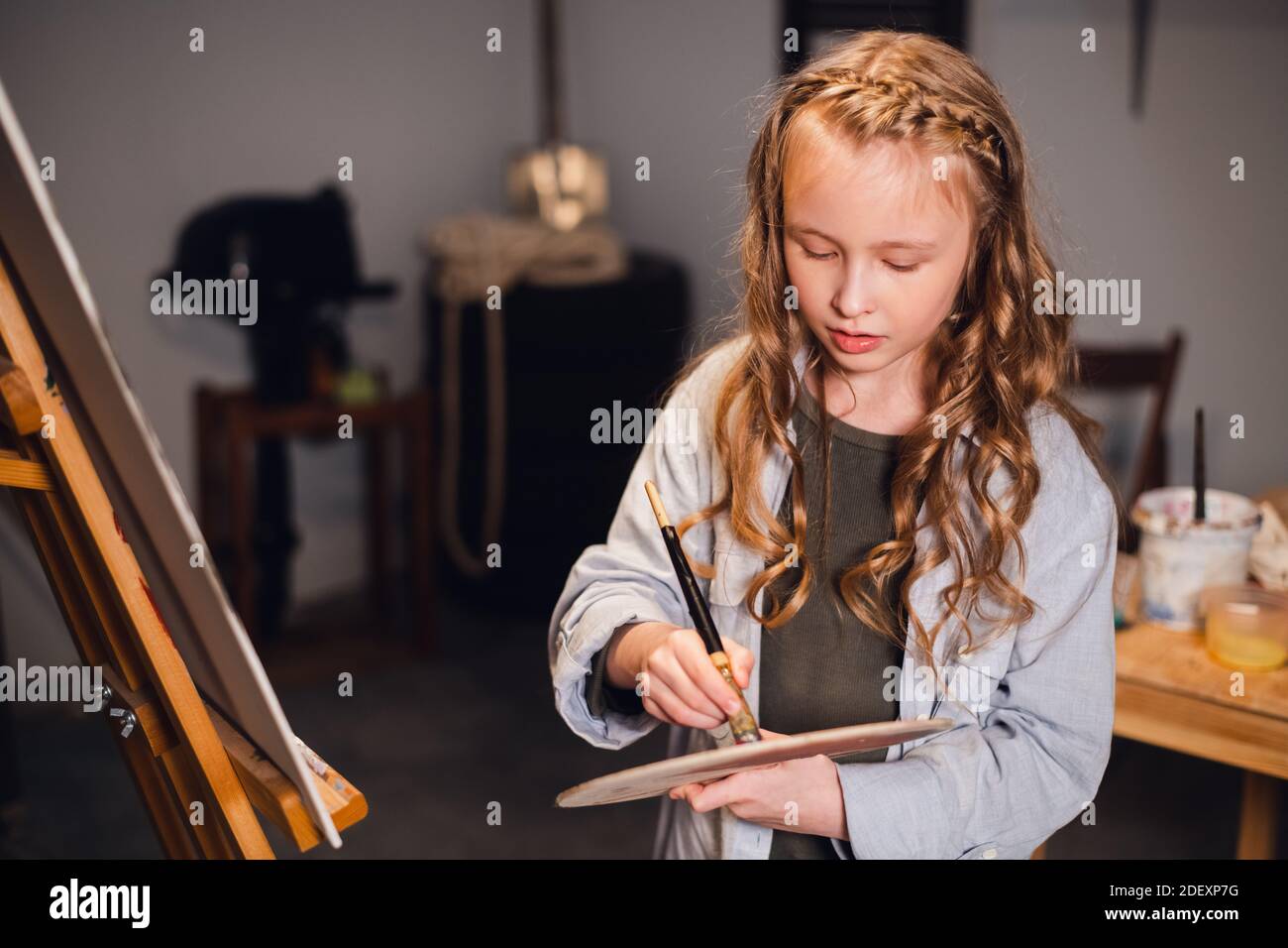 An art school student mixes colors on a palette for her canvas drawing ...