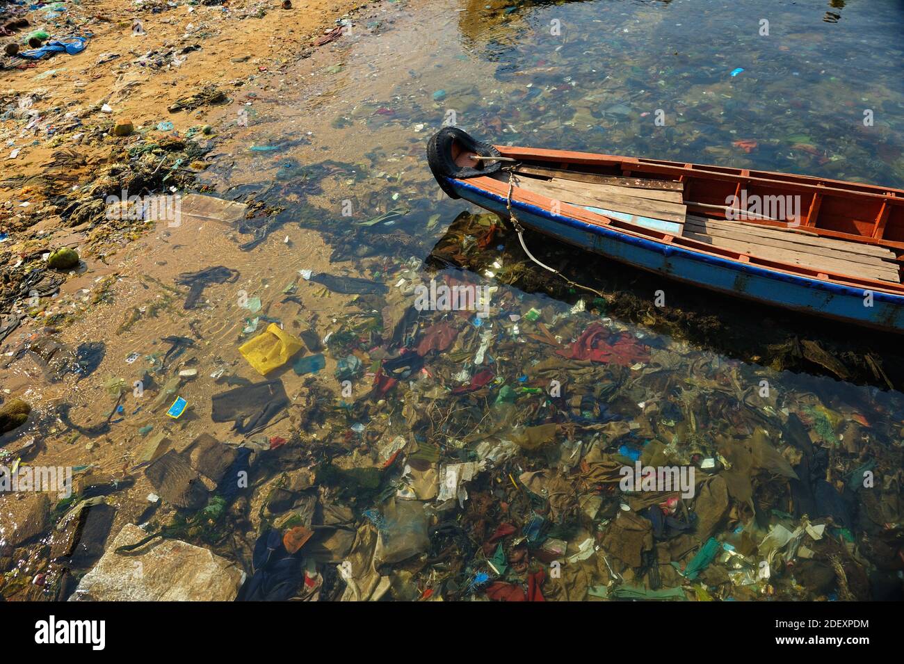Dump thrown back by sea. Stranded objects polluting clear, transparent ...