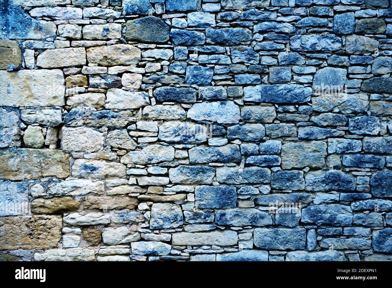 Ancient stone wall texture with blue denim cast Stock Photo - Alamy