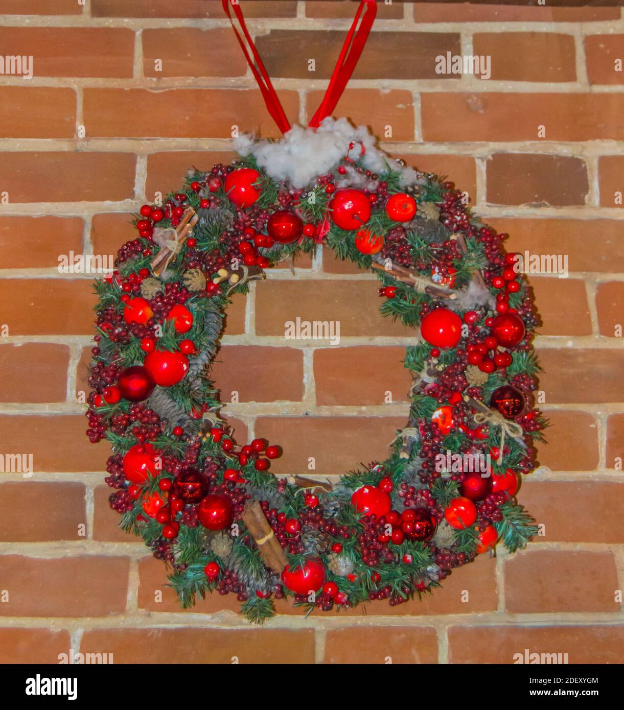 Handmade Christmas wreath on a red brick wall background. Festive ...