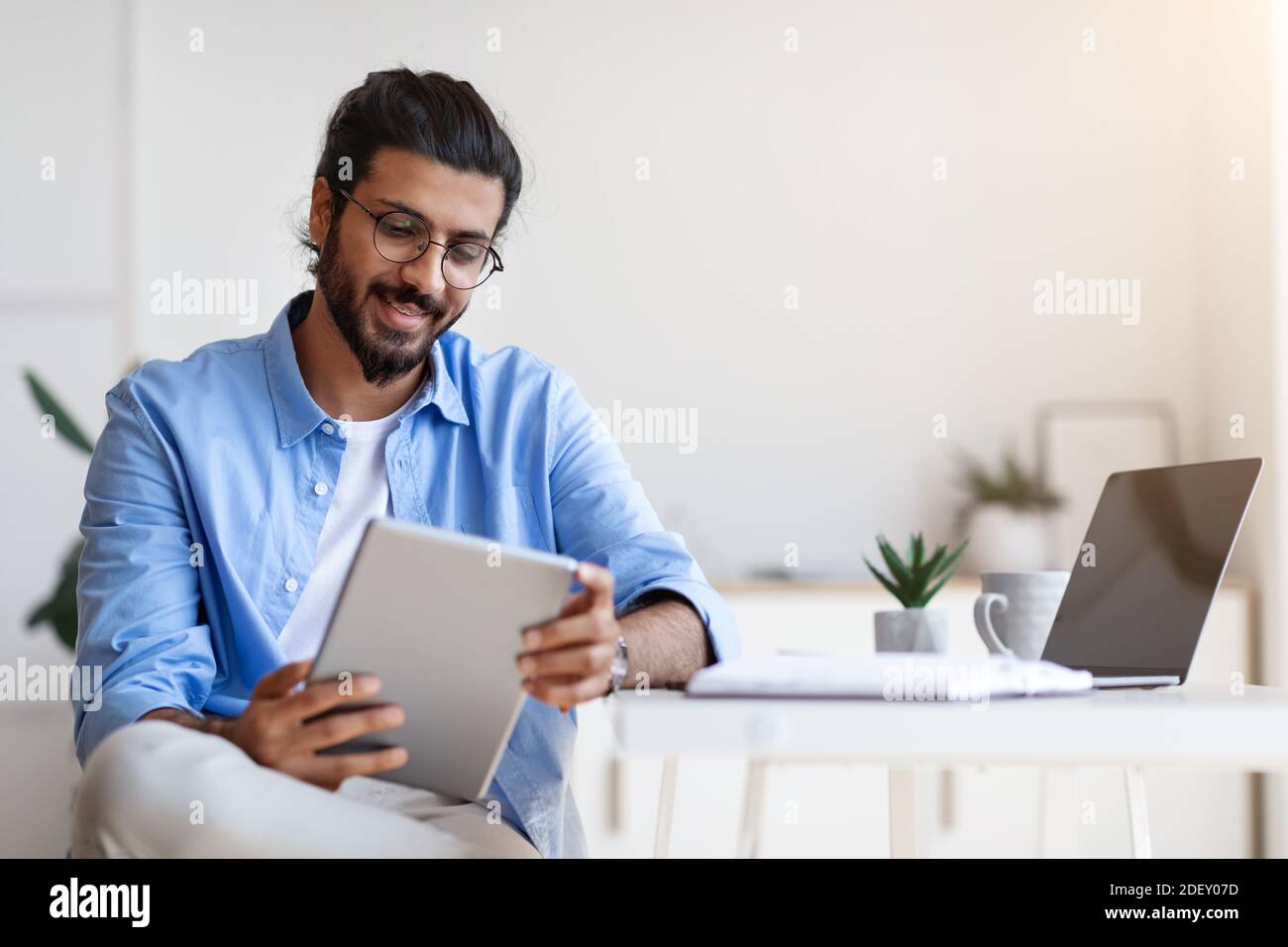 Indian guy reading tablet hi-res stock photography and images - Alamy