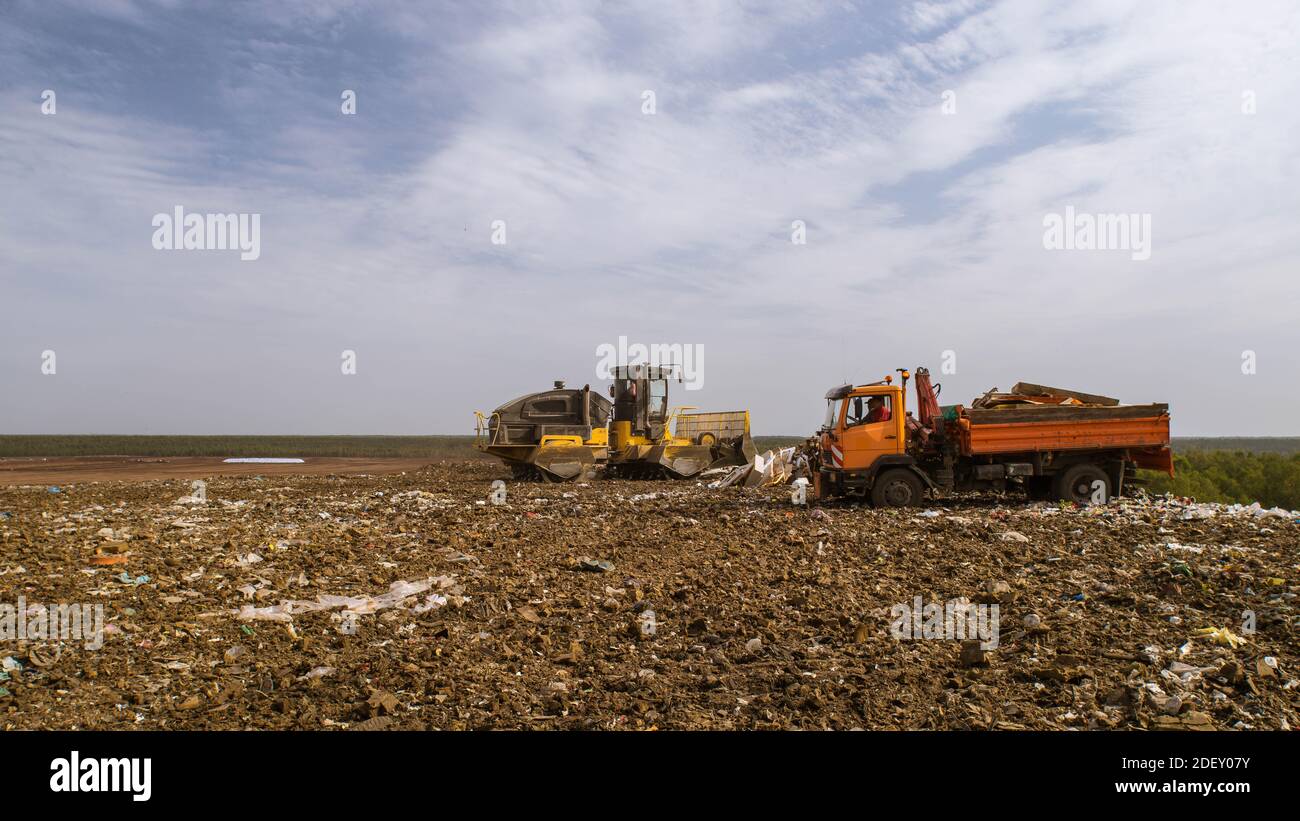 Huge dump of big city. Waste sorting on landfill. Truck and tractor ...