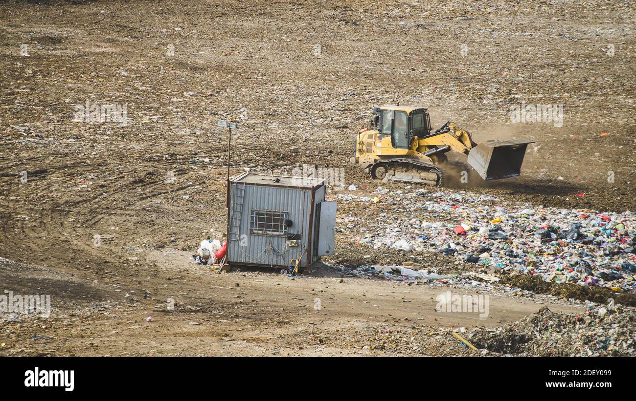 Huge dump with household garbage. Yellow tractor. Waste sorting on ...