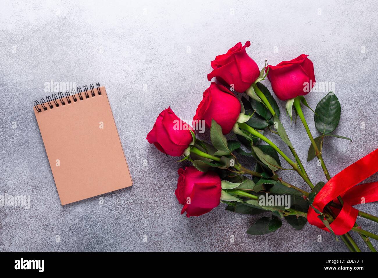 Red rose flowers bouquet, notebook on stone background Valentine's day ...